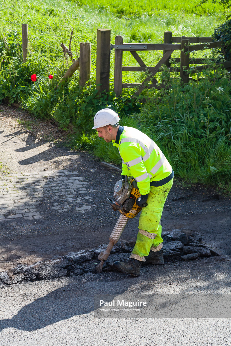 Stock photo - Man repairing potholes in UK road - Paul Maguire