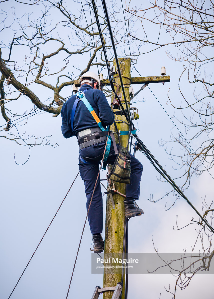 Stock photo - Telecoms engineer climbing telegraph pole, phone line ...