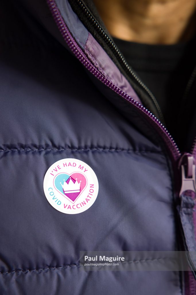 Stock photo - Asian person wearing an NHS COVID vaccination sticker, UK ...